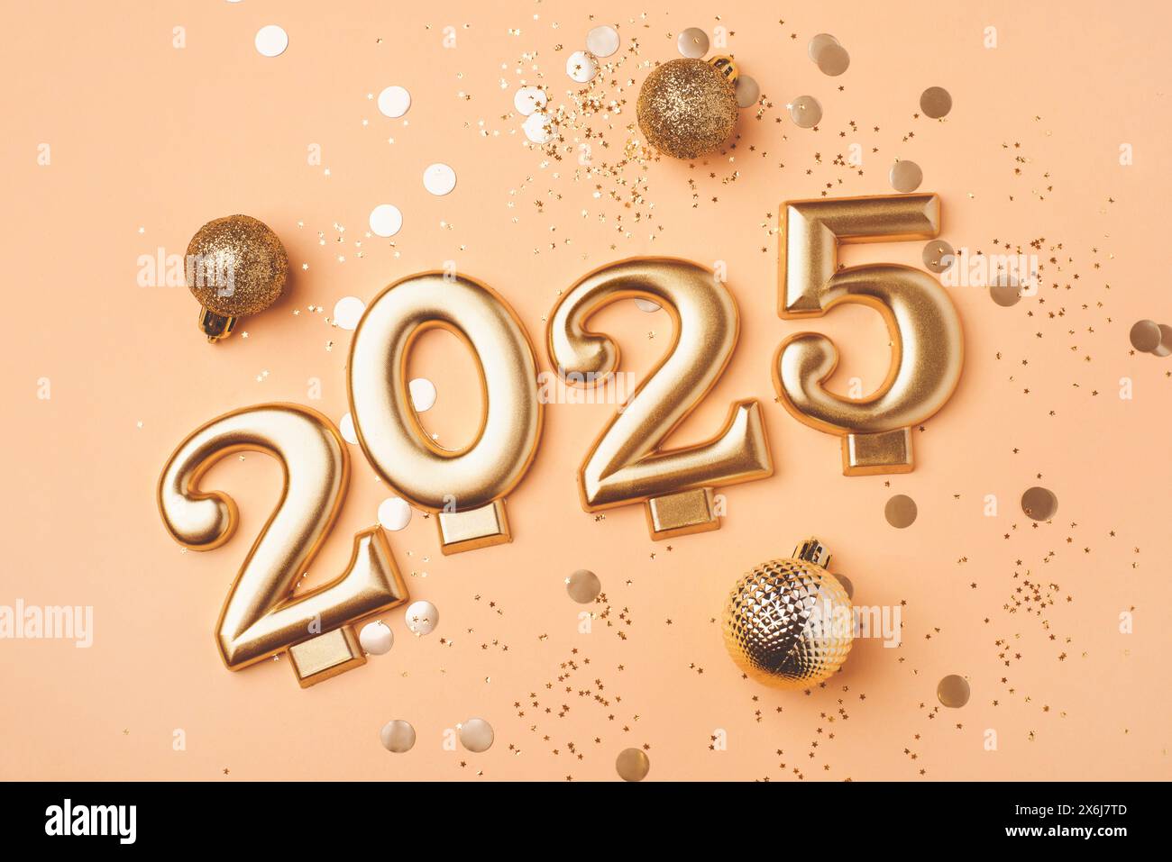 Golden 2025 on a peach color background with confetti and bokeh lights. Happy New Year 2025 is ...