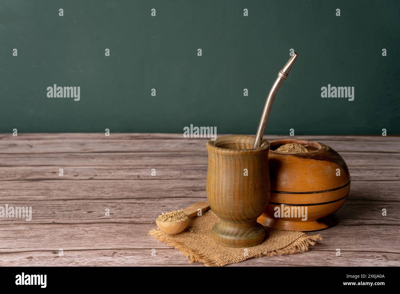Calabash with Yerba Mate tea and bombilla on wooden table on light gray ...