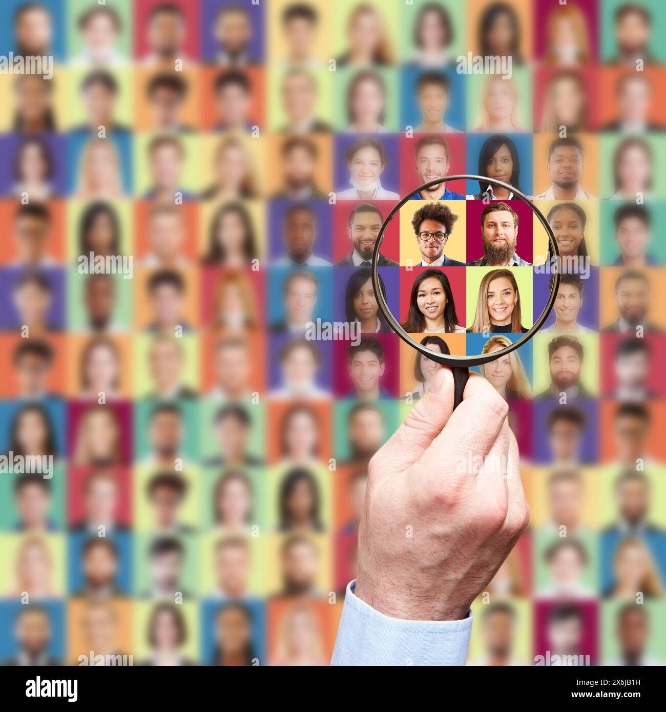 Hand with magnifying glass searches among young people for suitable ...