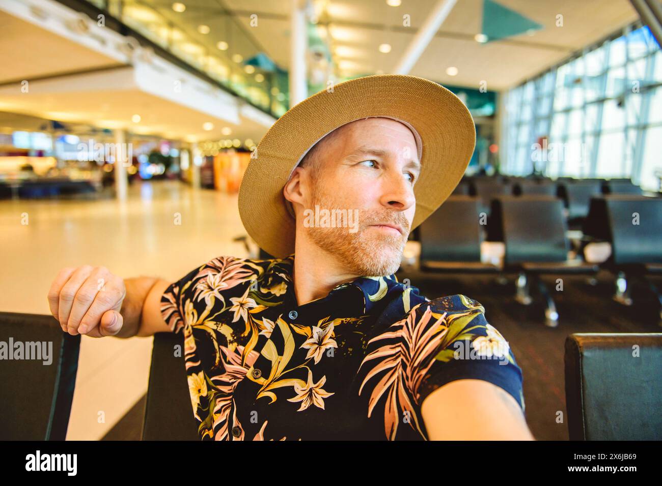 man is waiting at the airport. He is sitting on bench Stock Photo - Alamy