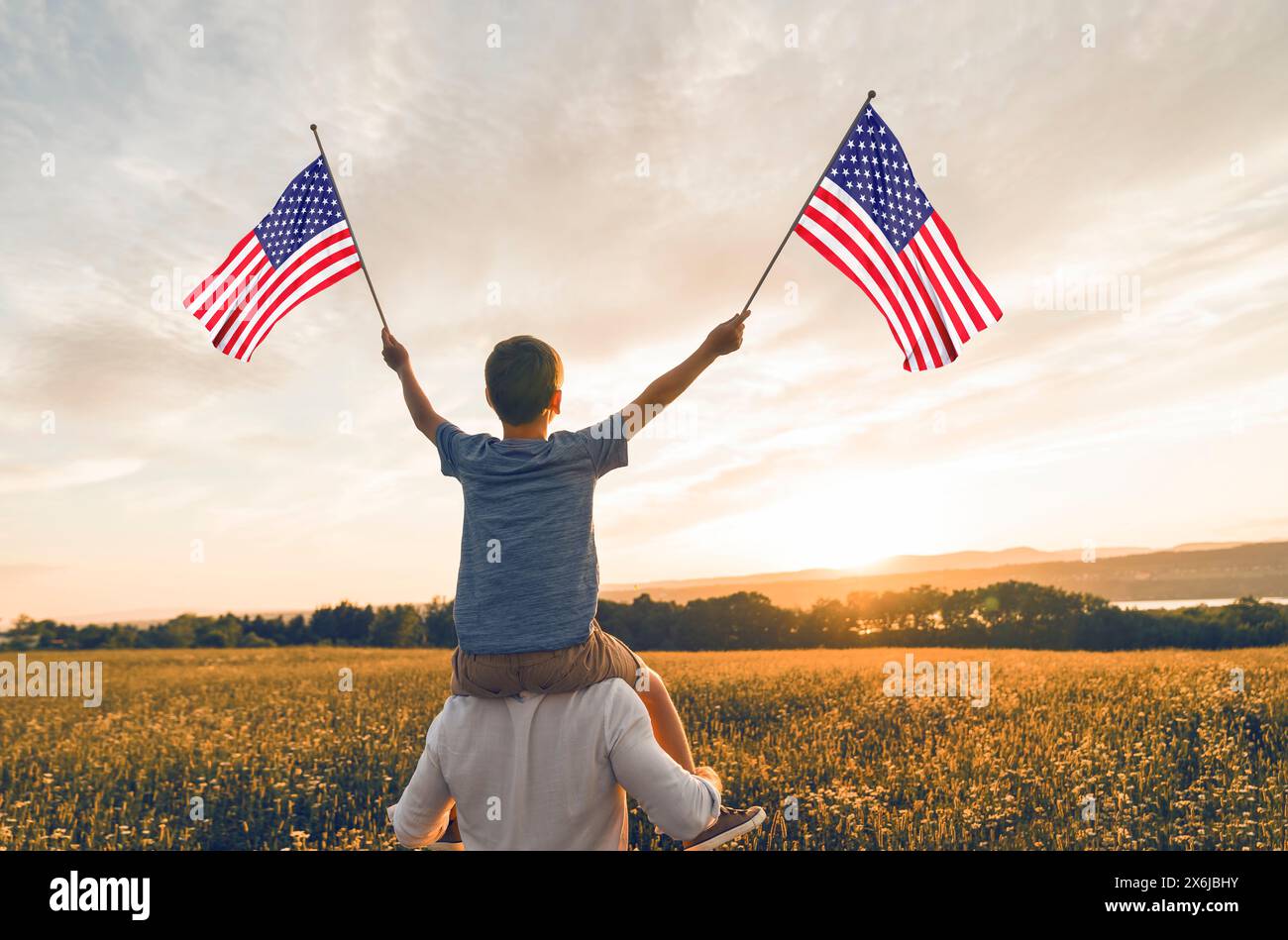 Patriotic father and child waving American USA flags on sunset Stock ...
