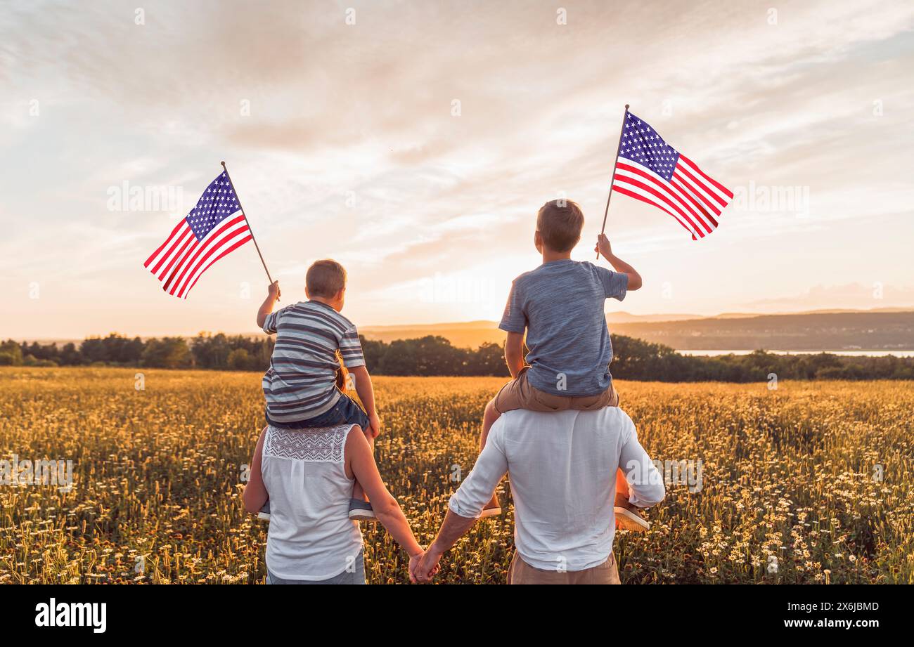 Patriotic family waving American USA flags on sunset Stock Photo - Alamy