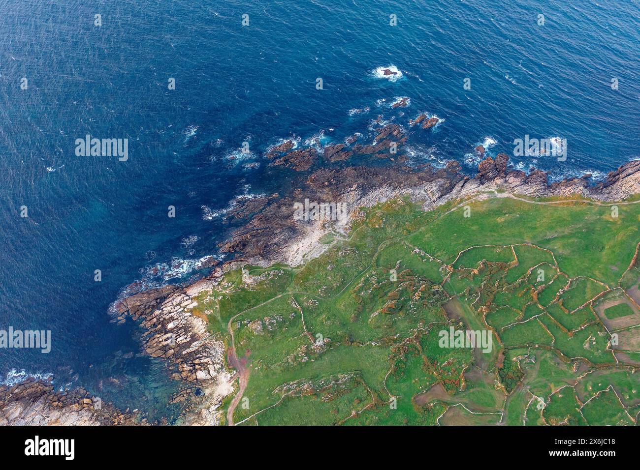 Rocks on the ocean shore. Coastline, blue water, green grass Stock ...