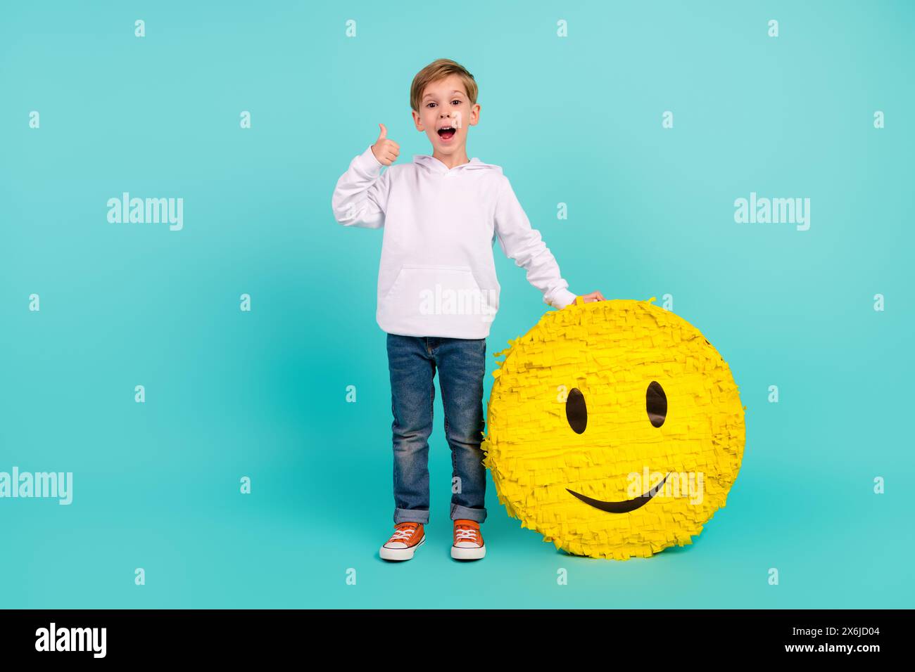 photo of funky adorable schoolboy having smiley face emoji make thumb ...