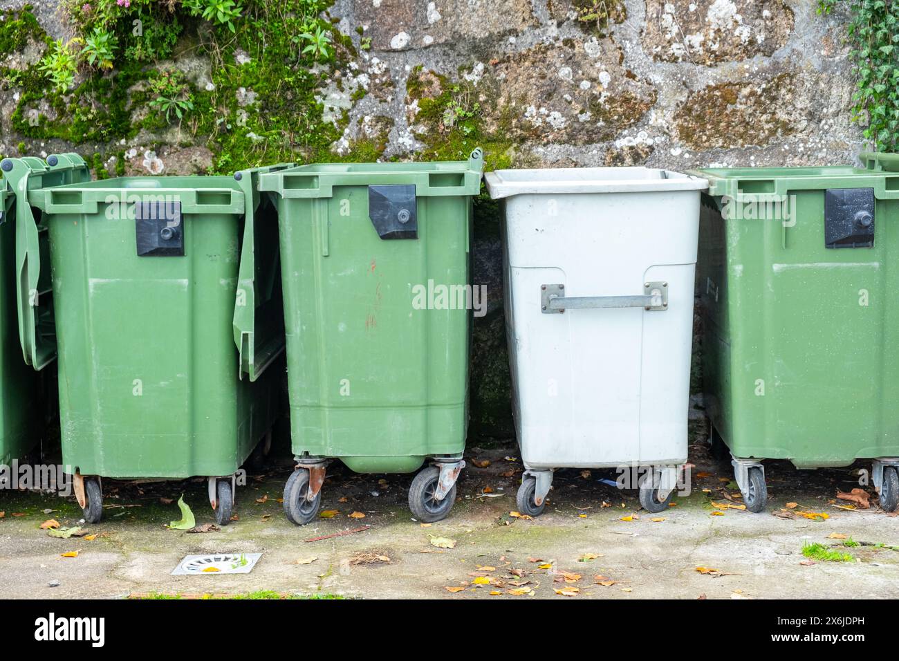 four plastic garbage containers lined up in a row Stock Photo - Alamy