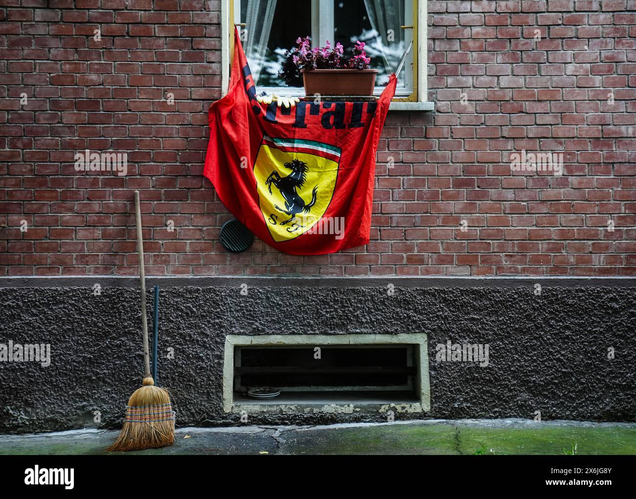 A Ferrari flag hangs from an apartment window next door to the Ferrari ...