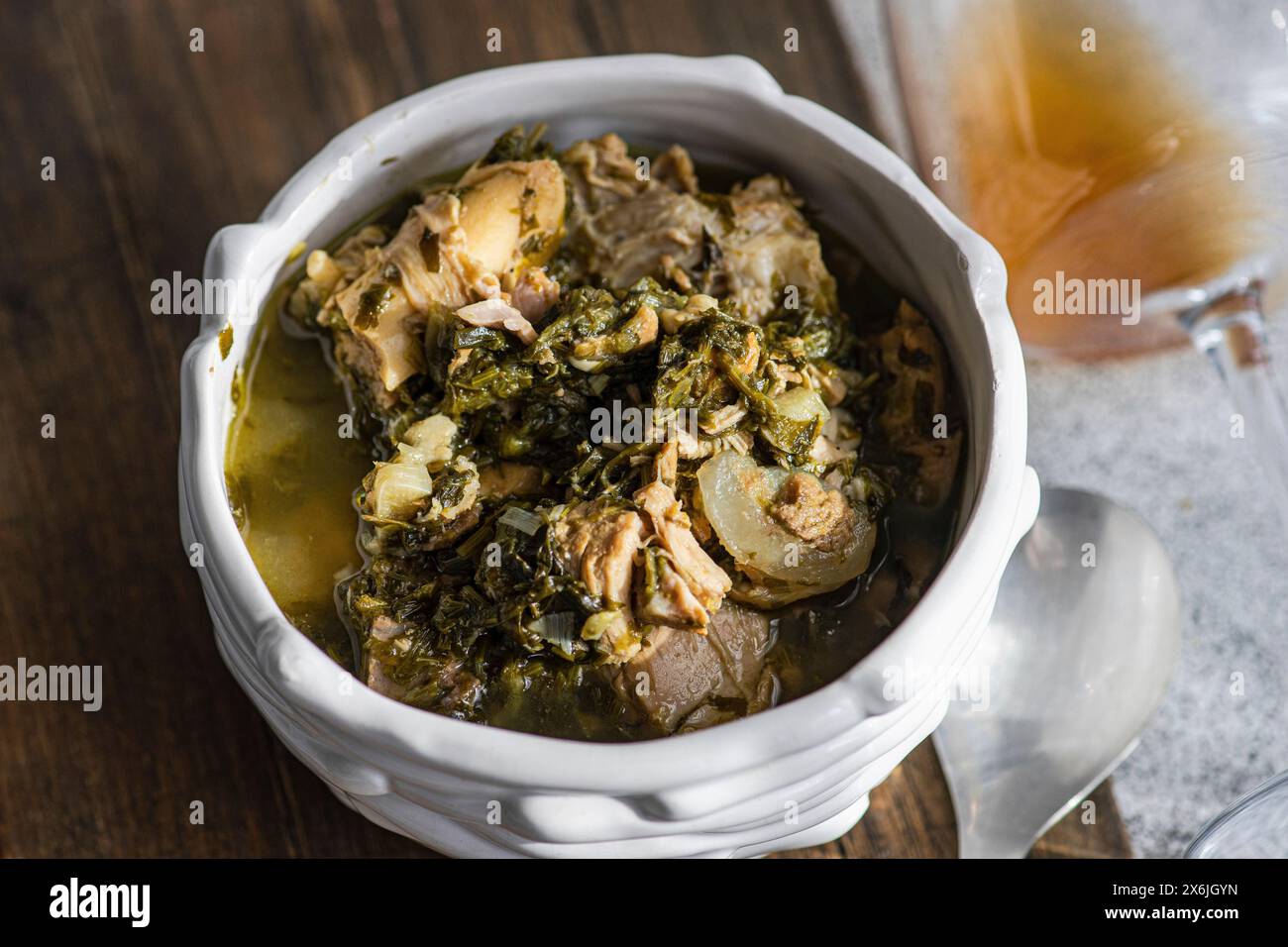 Traditional Georgian dish Chakapuli in a bowl and a glass of amber wine ...