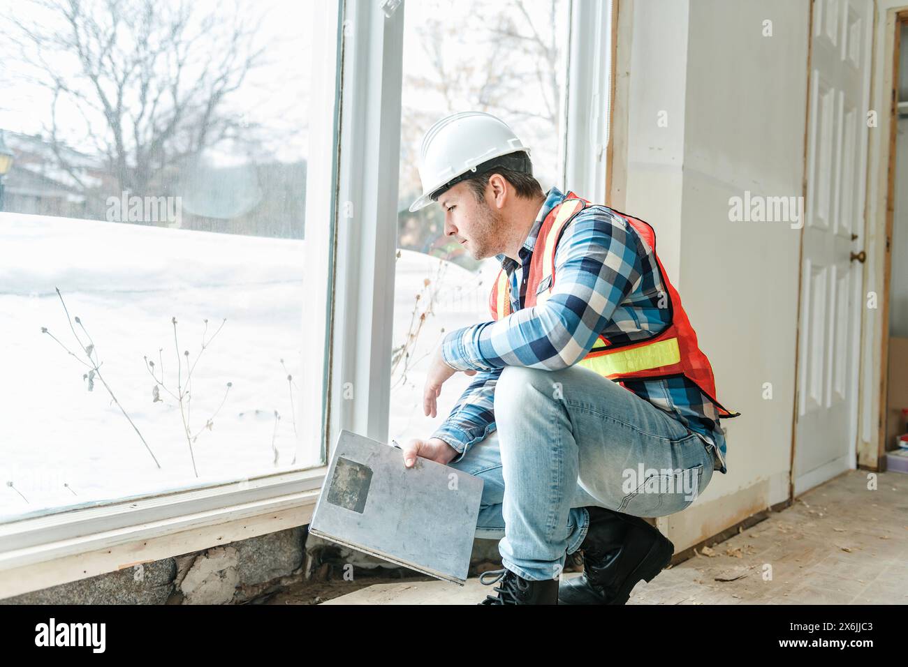 Inspector with white helmet inspecting an old house to be sure ...