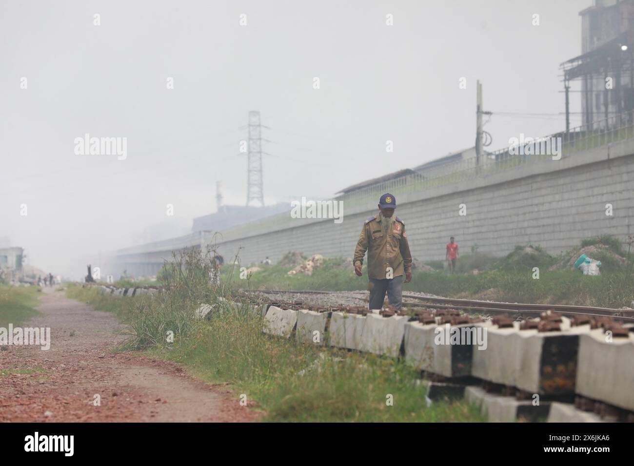People pass an industrial area as smoke rises from re-rolling mills at ...