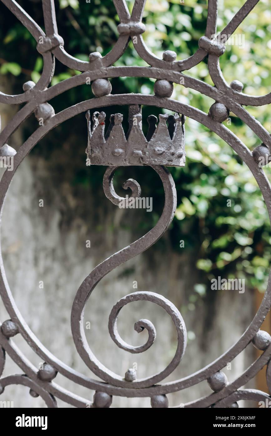 Wrought iron fence lattice with the image of the crown Stock Photo - Alamy
