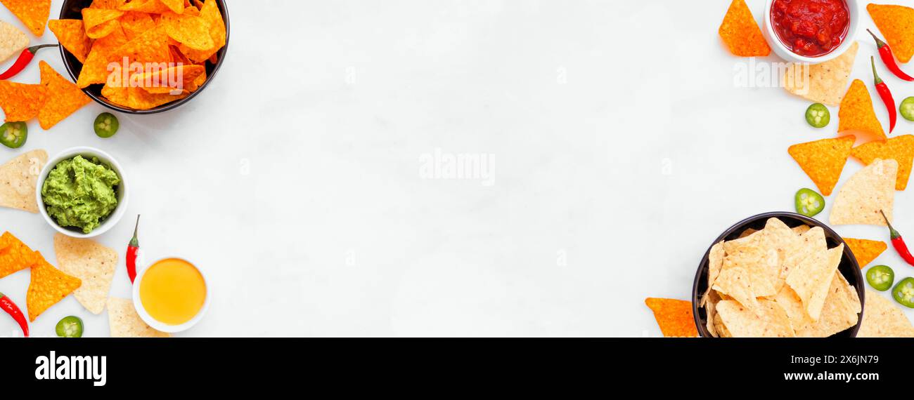 Nachos and dip double border. Top down view on a white marble banner ...