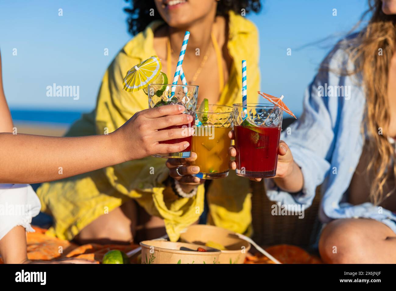 Summer celebration, friends cheers with colorful cocktails at the beach ...