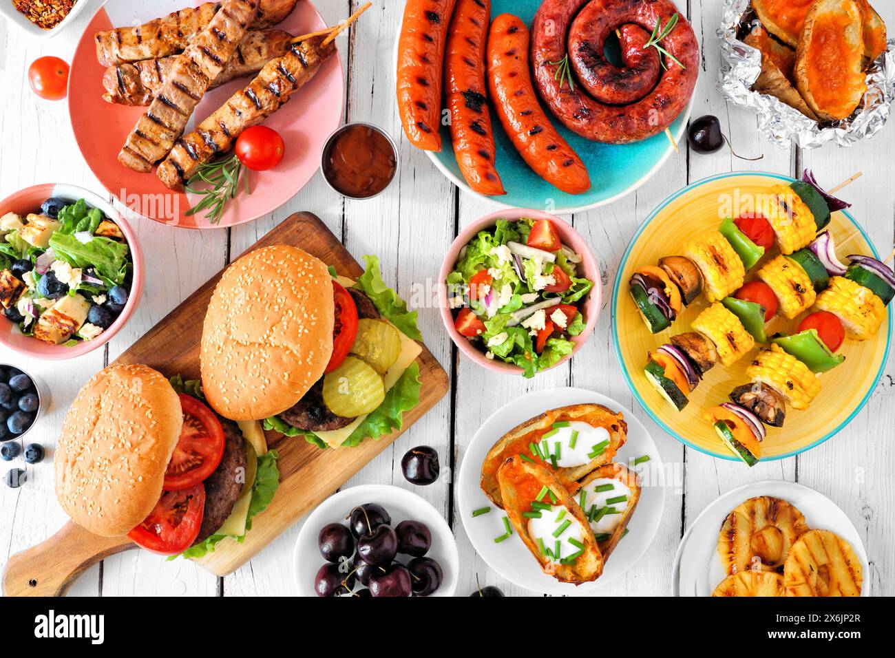 Summer BBQ or picnic food table scene. Assortment of burgers, grilled ...