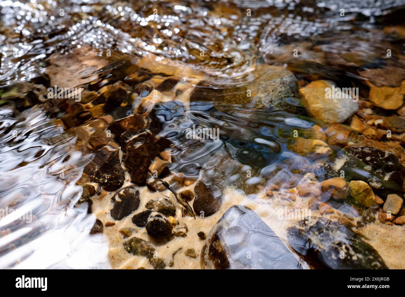 Creek rocks, waters flow and waves reflections in close-up Stock Photo ...
