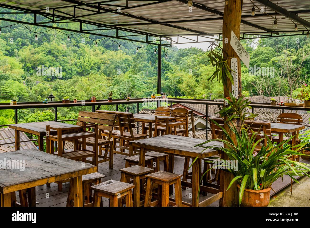 Empty tables and chairs on covered balcony of restaurant overlooking ...