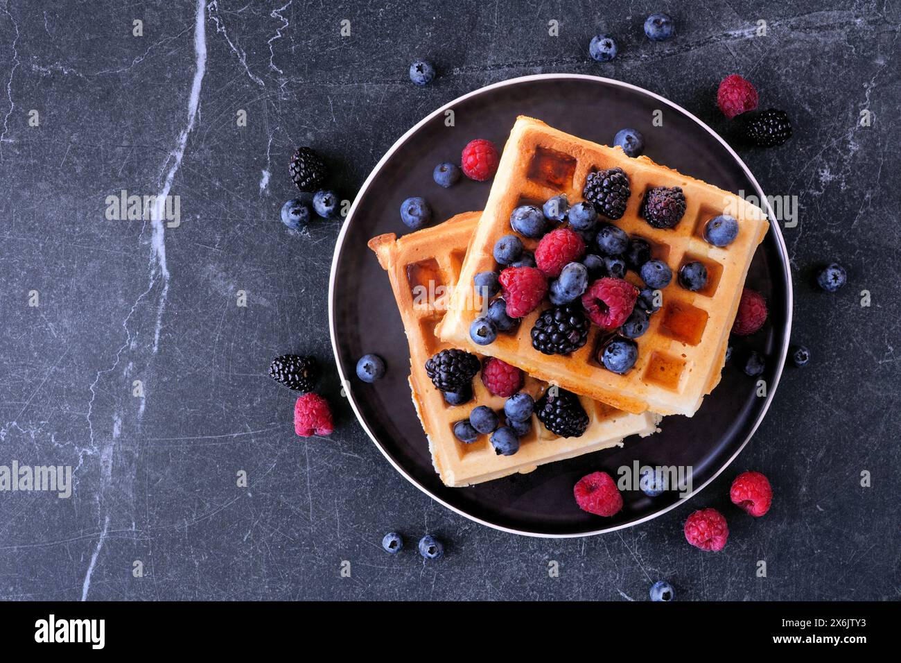 Breakfast waffles with raspberries and blueberries. Top view over a ...