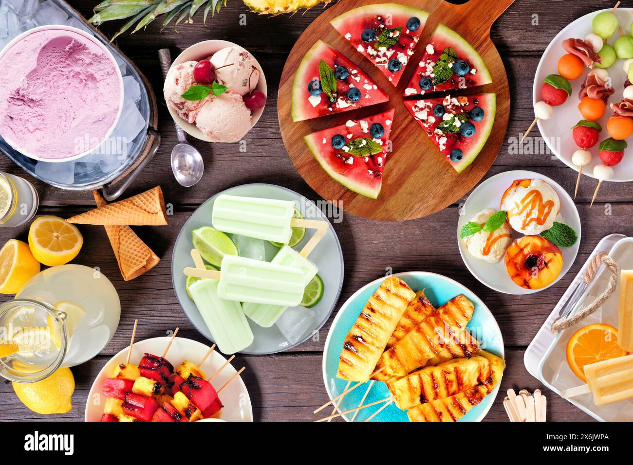 Refreshing summer food table scene. Assorted grilled fruits, ice cream ...