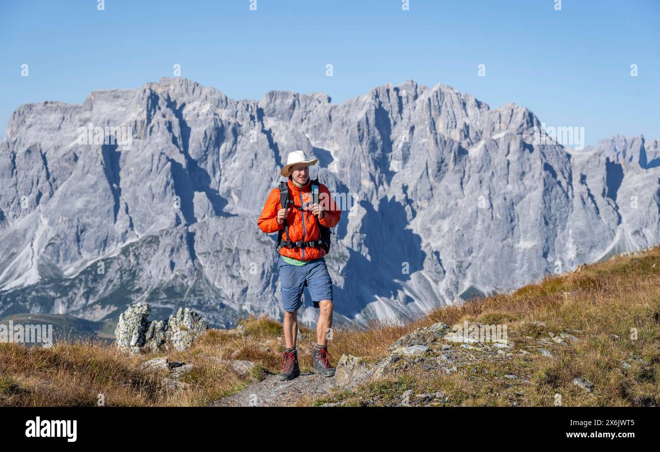 Mountaineer on hiking trail in front of rocky mountain peaks, behind ...