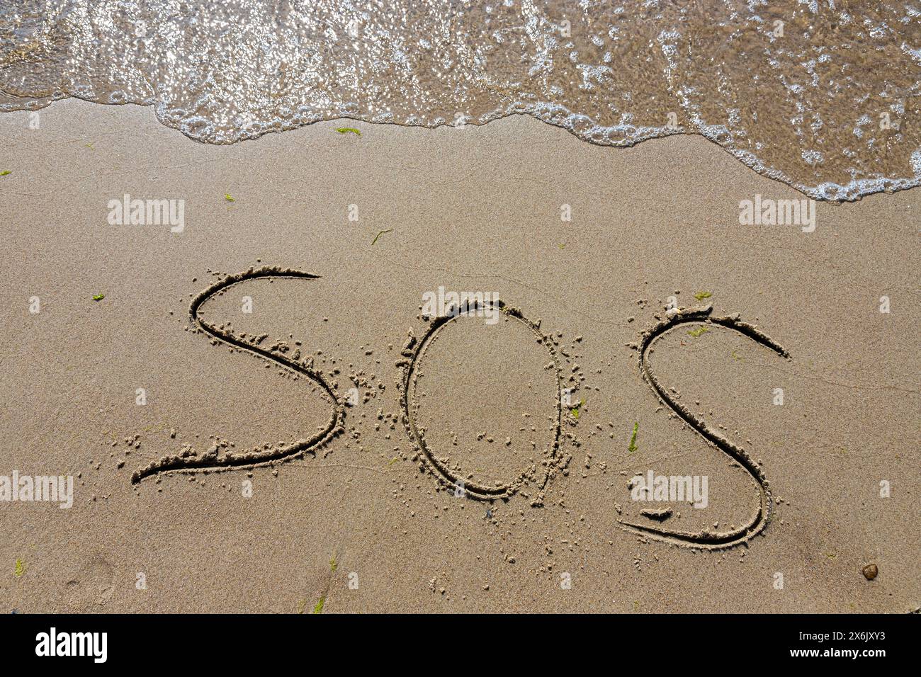 The inscription on the sand at the beach sos Stock Photo - Alamy