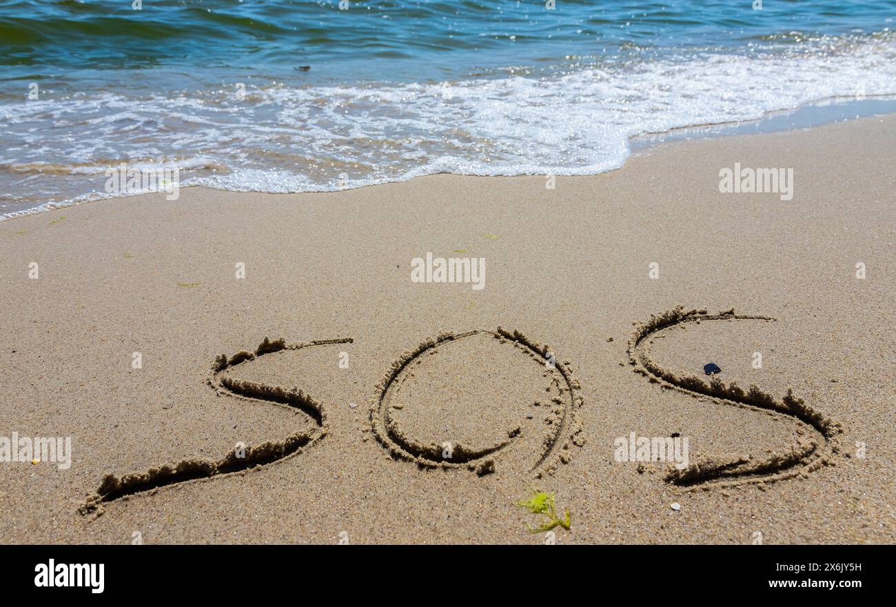 The inscription on the sand at the beach sos Stock Photo - Alamy