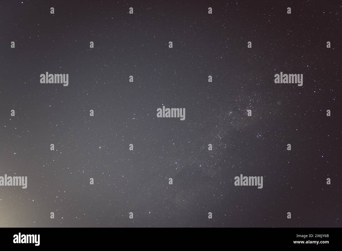 Wide starry sky above a light source at the bottom of the picture Stock ...