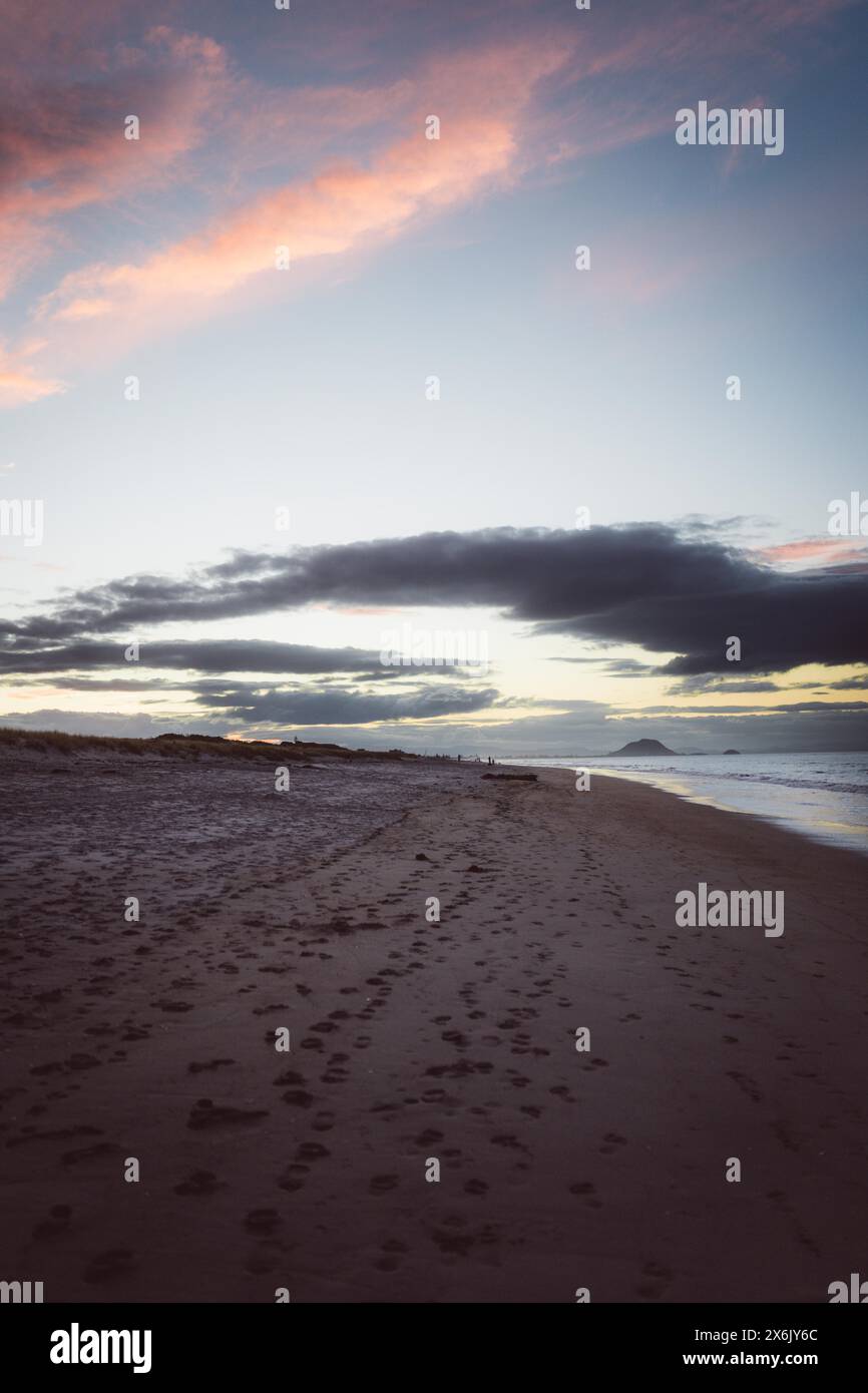 Sunset on the beach, purple sky and a calm sea. Taken in Papamoa Beach ...