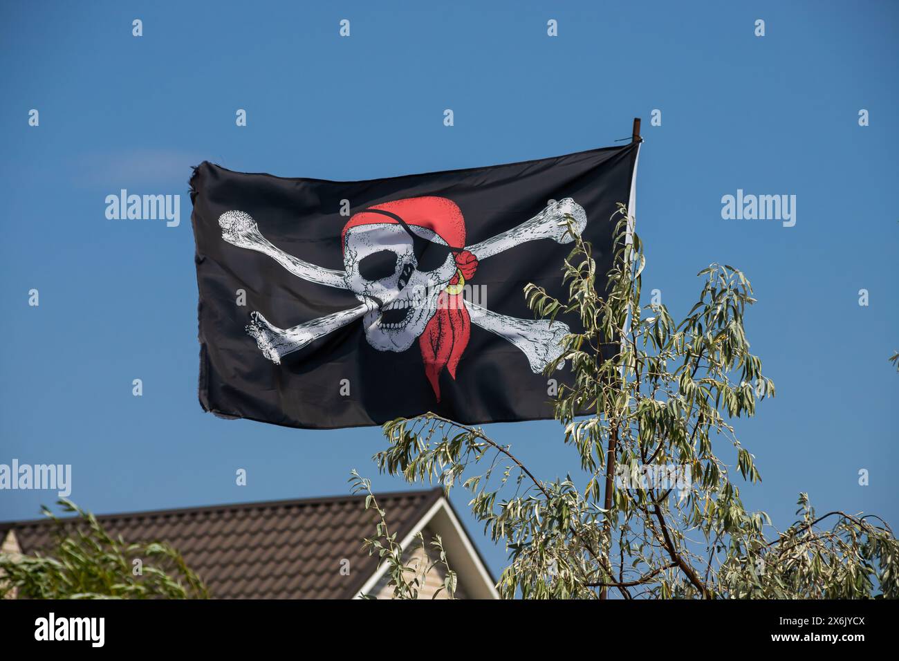 A skull and cross bones pirate flag waving in the wind Stock Photo - Alamy