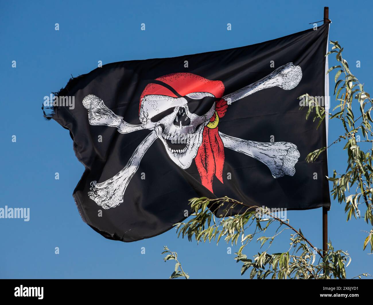 A skull and cross bones pirate flag waving in the wind Stock Photo - Alamy