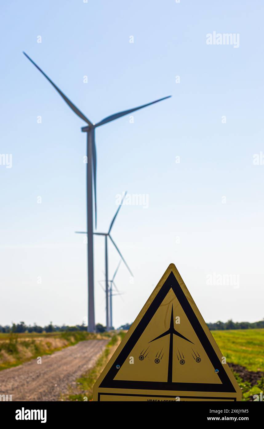 Wind Turbines with a caution sign warning of the dangers of approaching ...