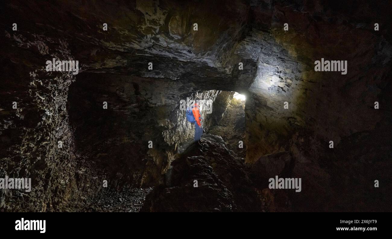 Hiker explores Obstans ice cave in Alta Pusteria, Carnic Alps, East ...