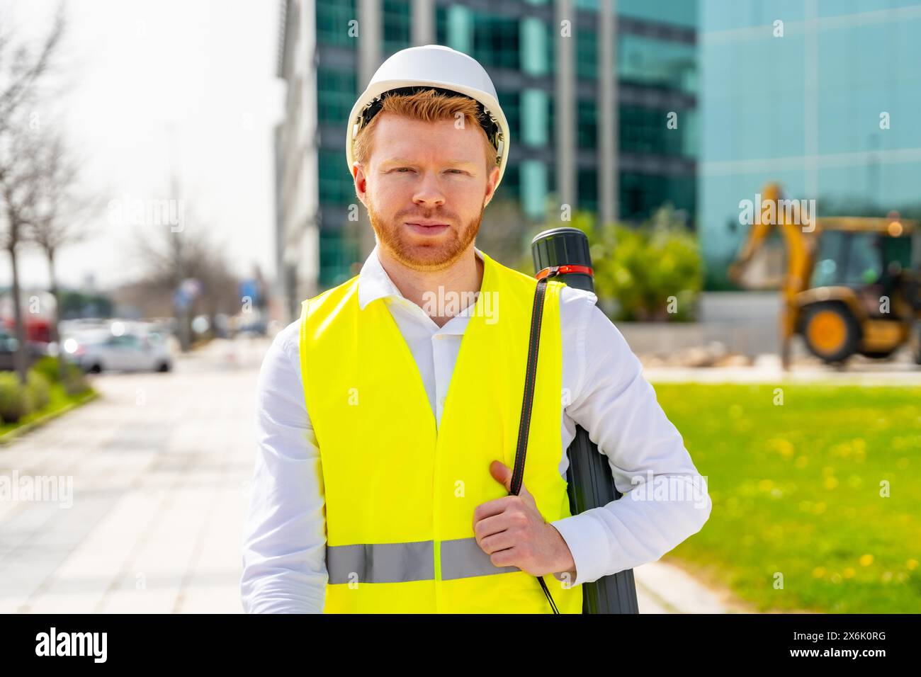 Portrait of an engineer with redhead standing with safe gear and a draw ...