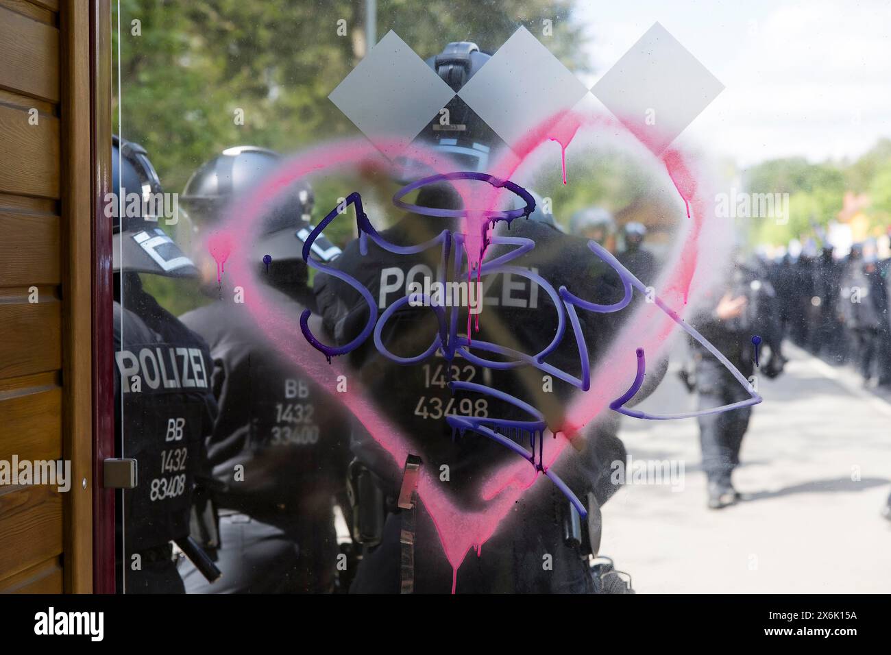 Police officers stand behind a spray-painted heart at a bus stop during ...