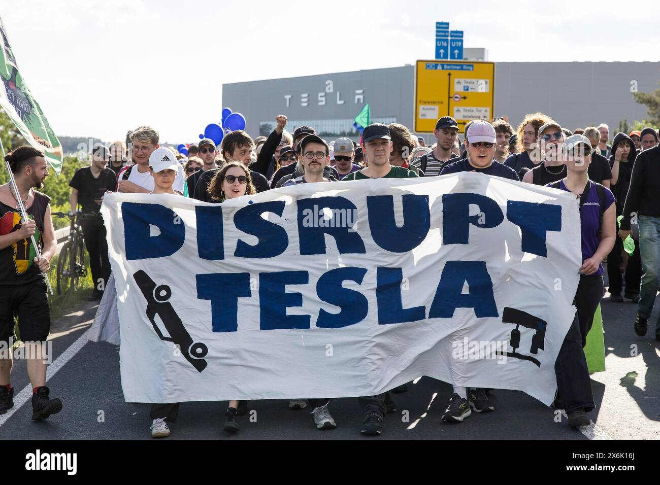 Participants with banner Disrupt Tesla in front of the Tesla ...