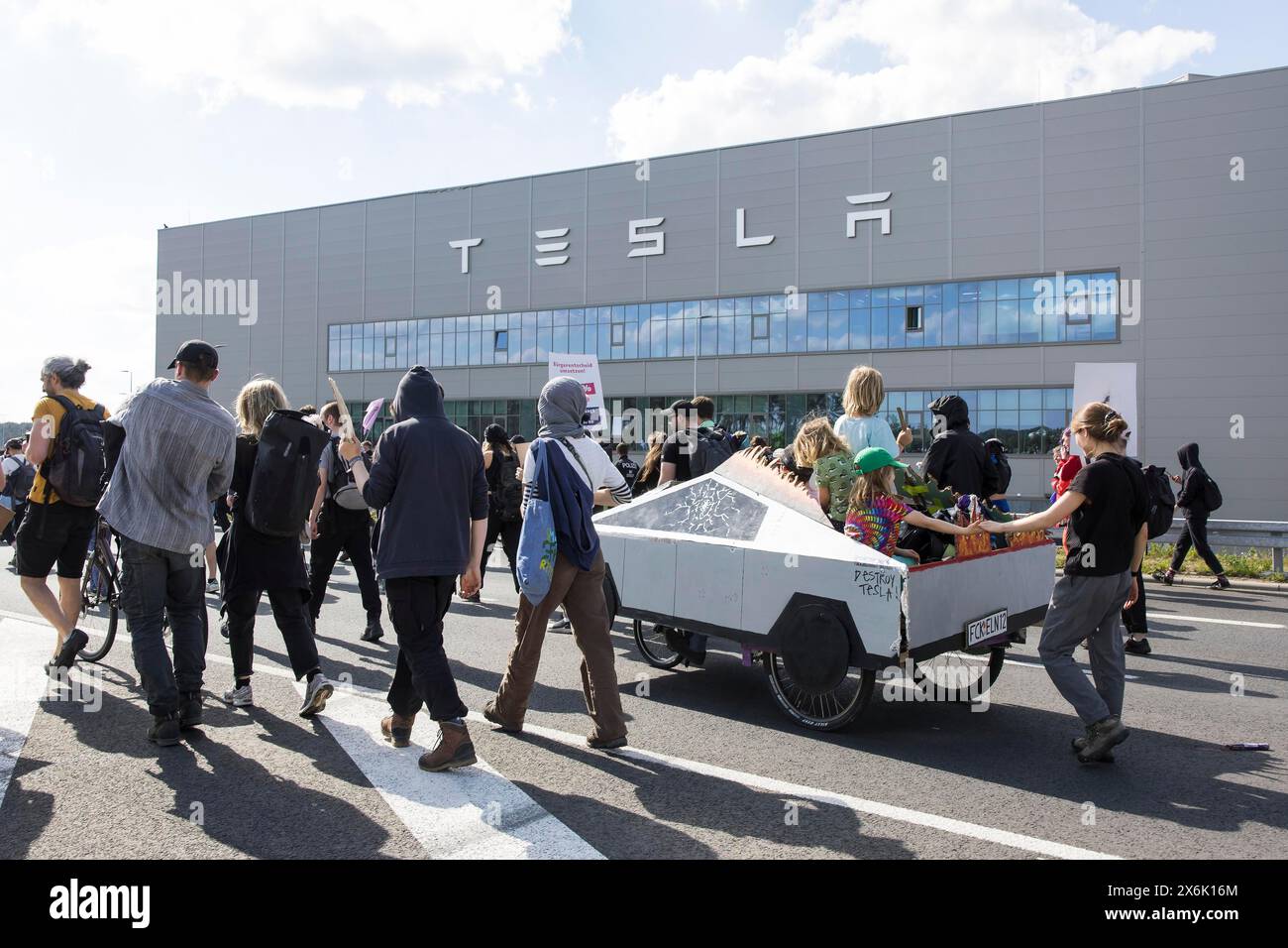 Participants with a Cybertruck cardboard model on a bicycle in front of ...
