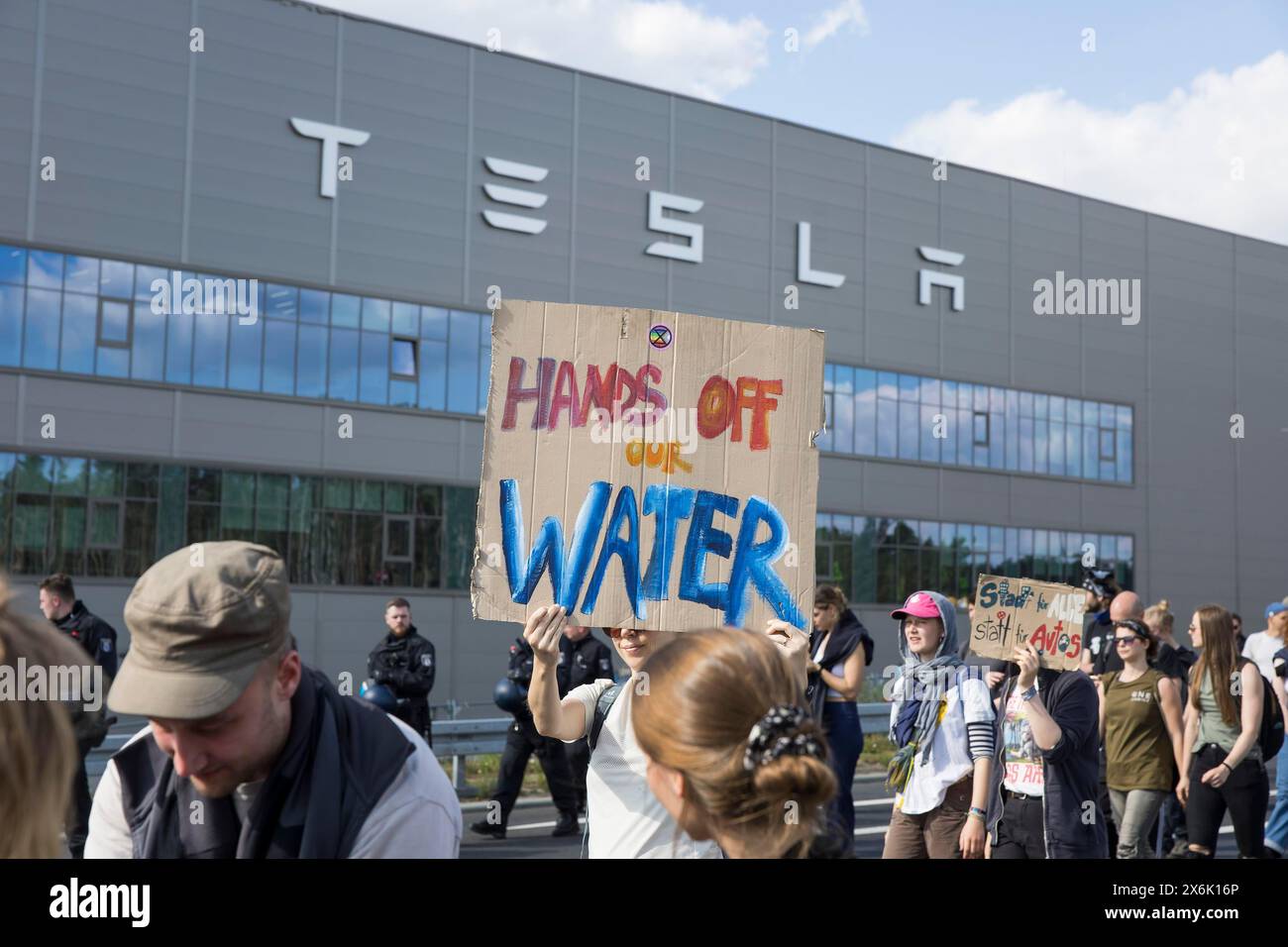 Participant with sign Hands off our water in front of the Tesla ...