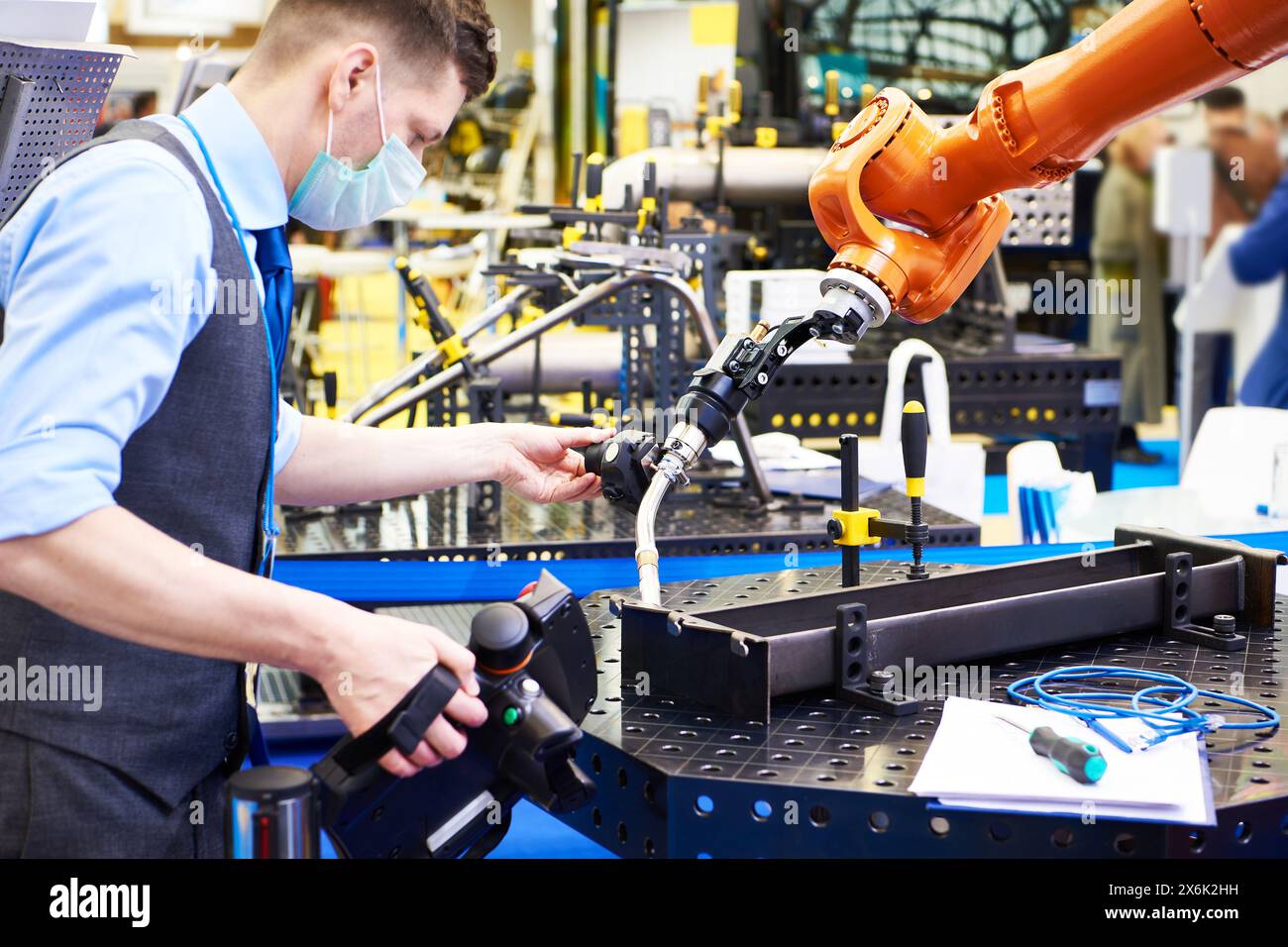 Operator controls a robotic welding machine at an exhibition Stock ...