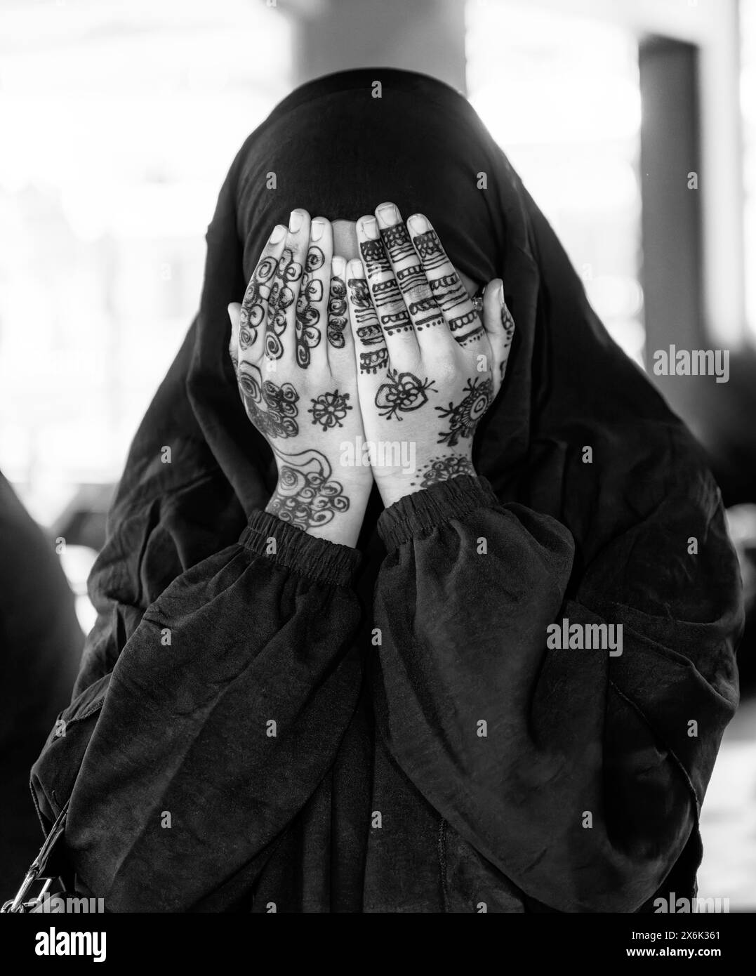 Muslims with hands in front of face SW Stock Photo - Alamy