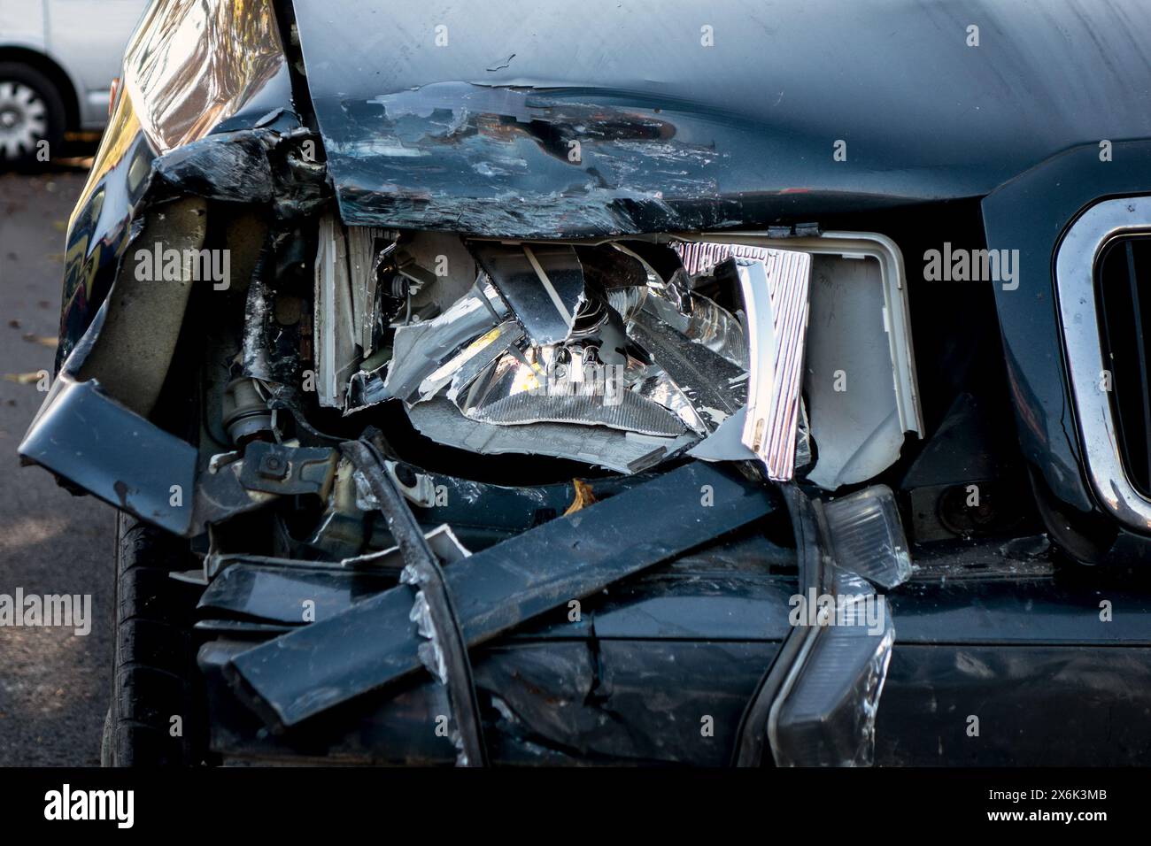 Detail of a broken headlamp on a dark blue car after traffic accident ...