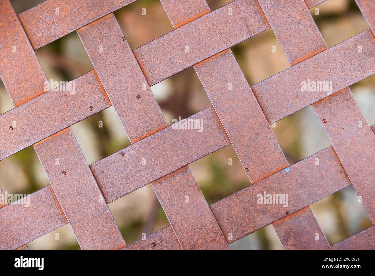 Abstract industrial photo. A grid of intertwined rusty metal strips is ...