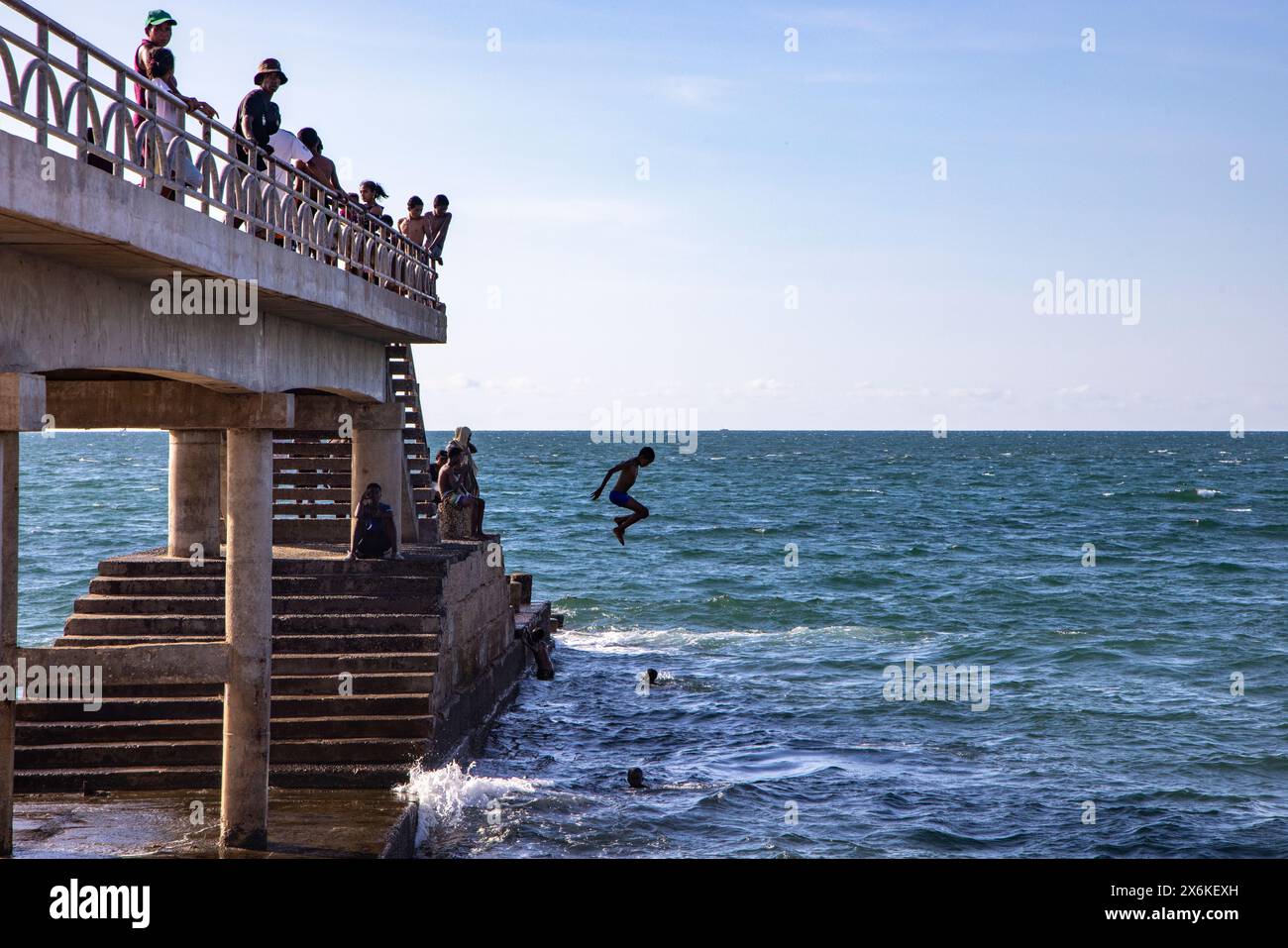Pier on the beach with people jumping into the sea, Mahajanga, Boeny ...