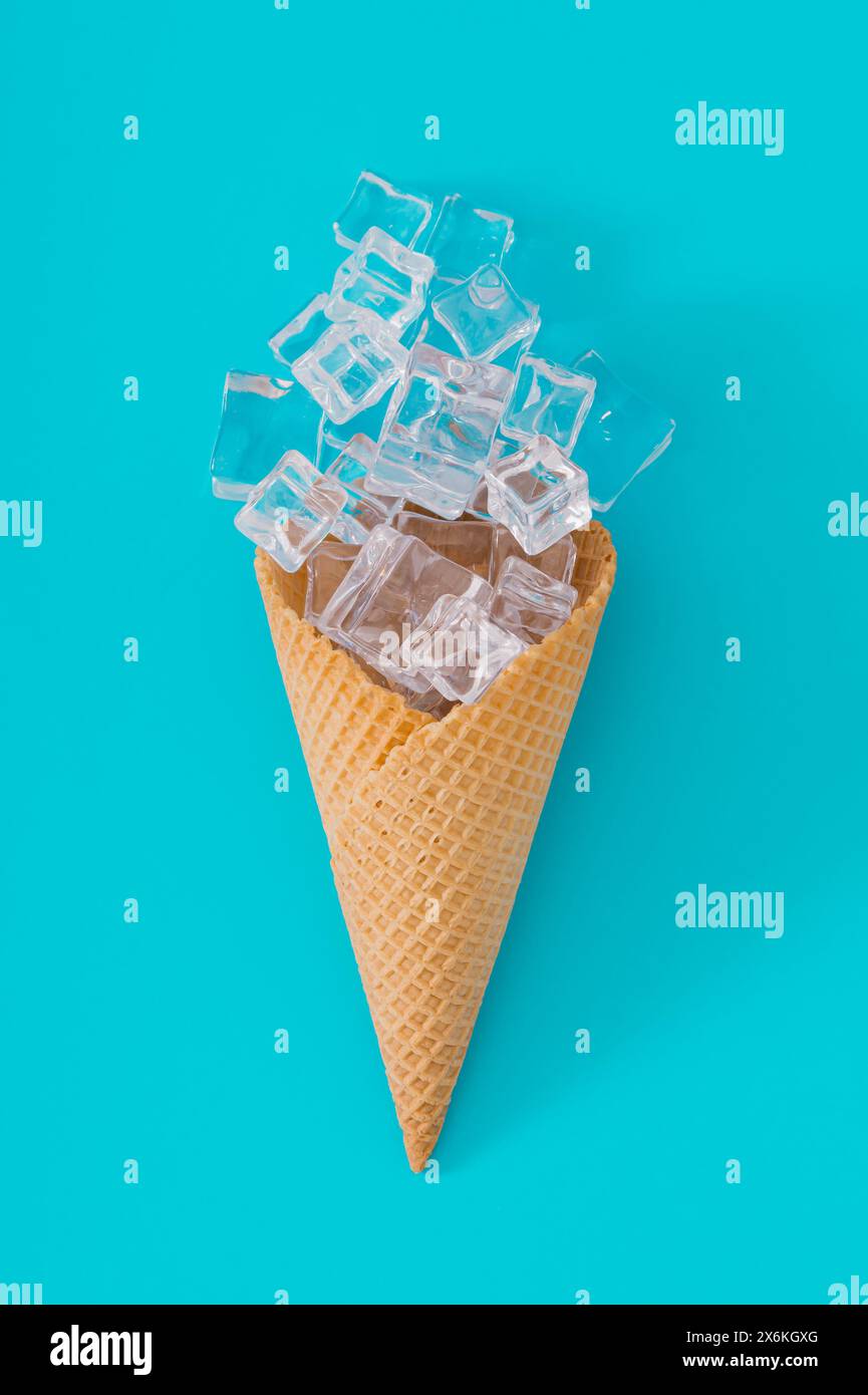 Ice cream cone with ice cubes on aqua blue background. Minimal summer ...