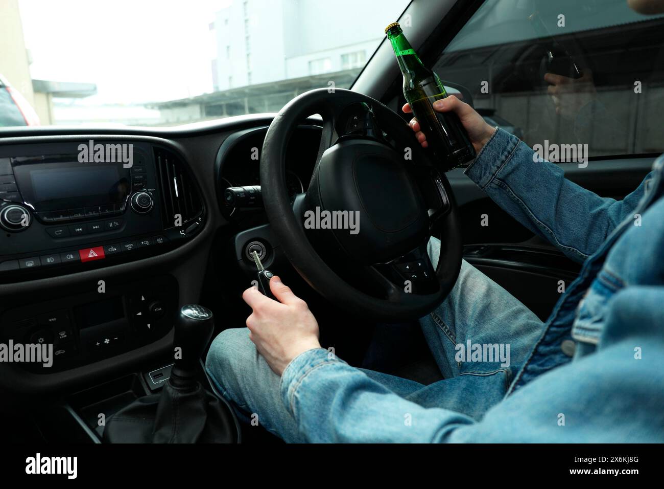 Man with bottle of beer driving car, closeup. Don't drink and drive ...