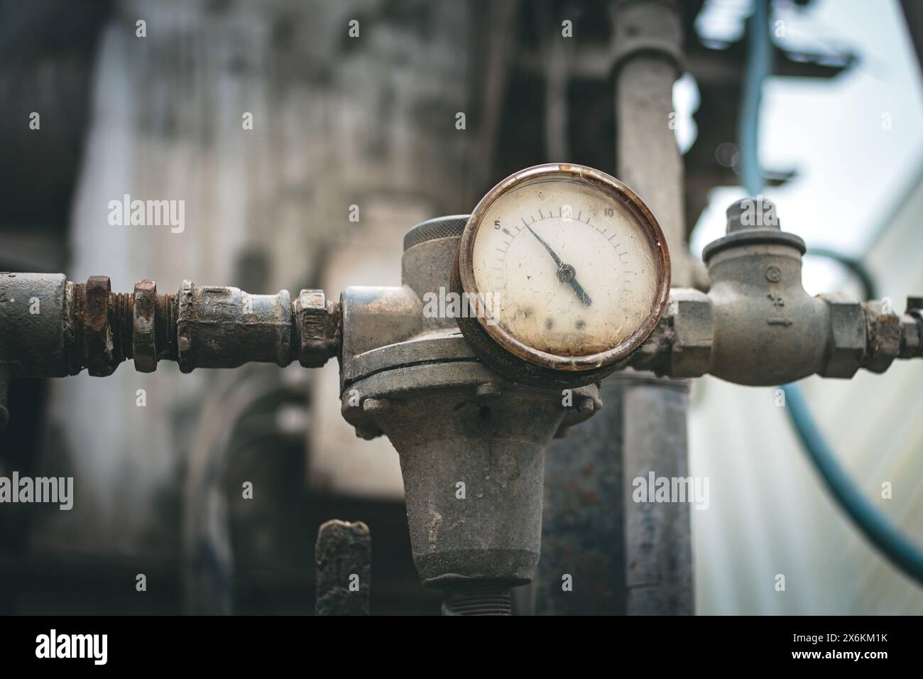 Worn out gauge displaying 6, mounted on pipes Stock Photo - Alamy