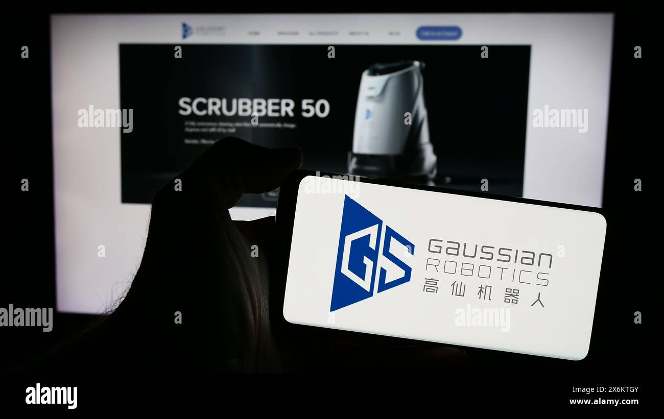 Person holding smartphone with logo of Singaporean company Gaussian ...