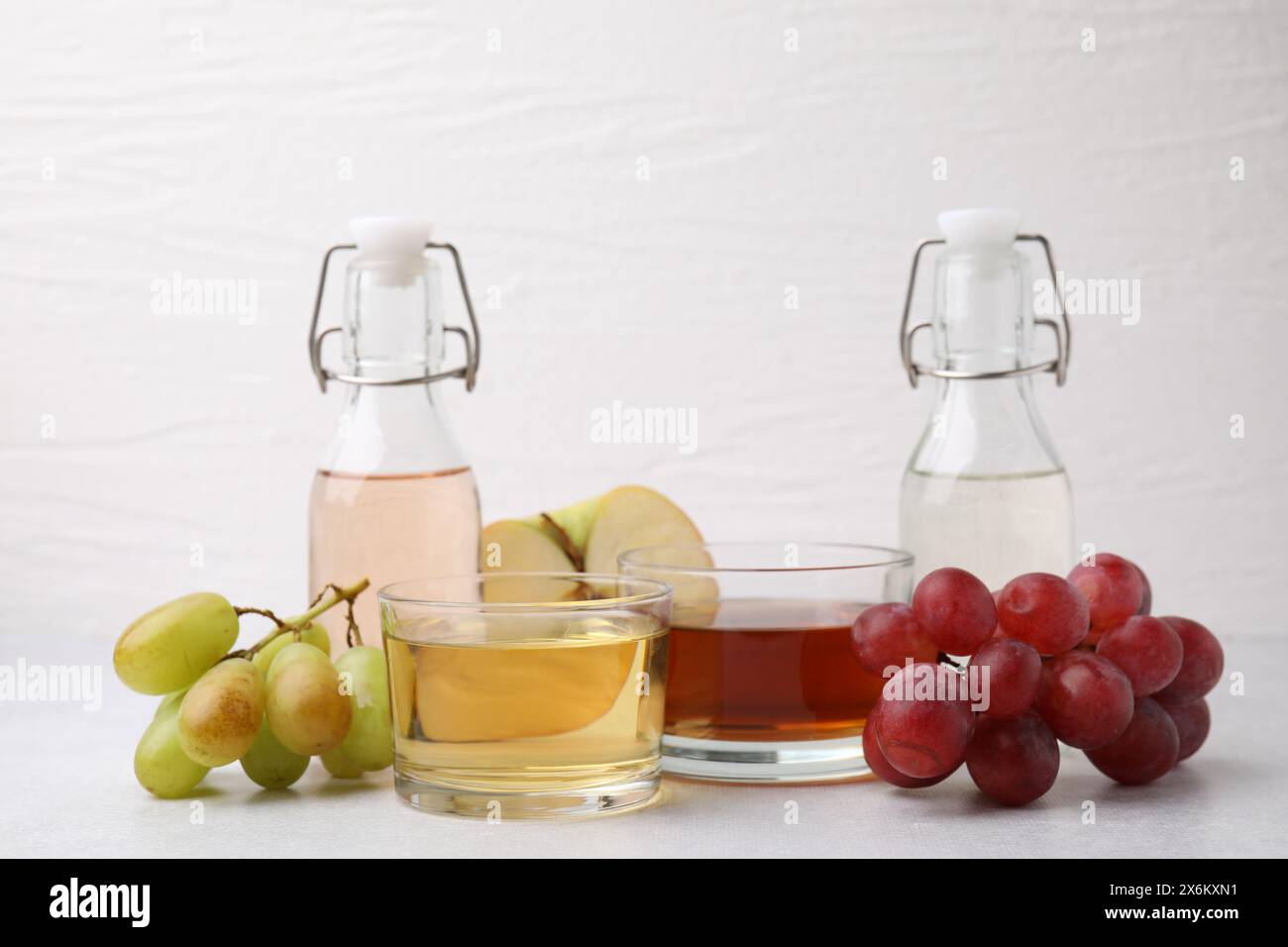 Different types of vinegar and ingredients on light table, closeup ...