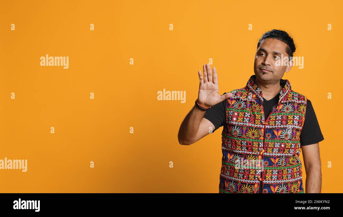 Indian man trying to stop chaotic fight using calming hand gesture to ...