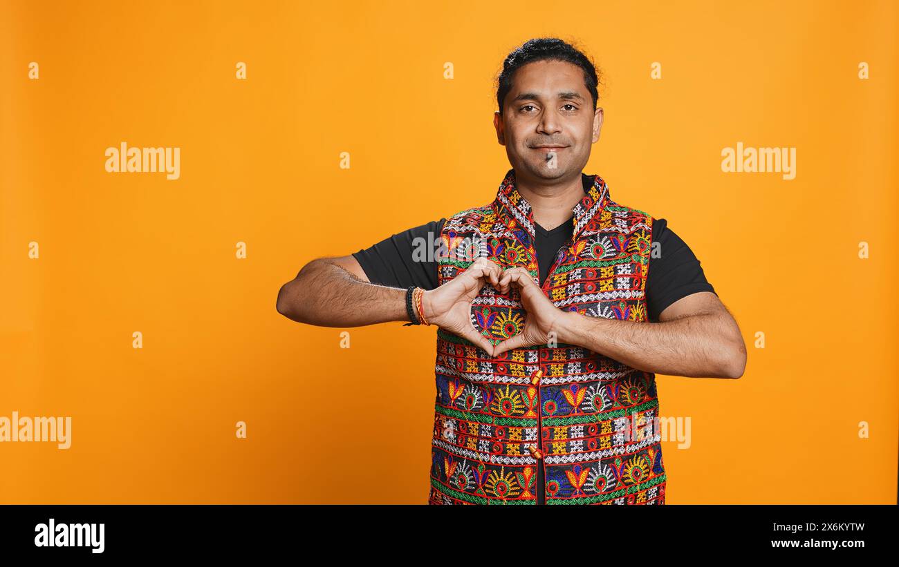 Portrait of jolly friendly indian man doing heart symbol shape gesture ...