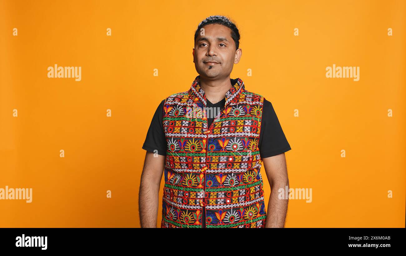 Portrait of jolly indian man with colorful garment smiling, looking ...