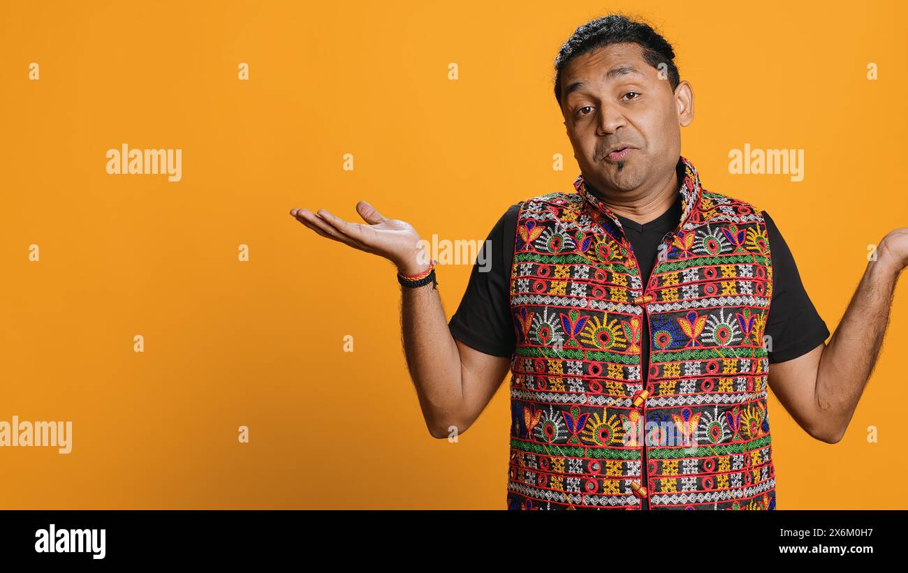 Indian man shrugging shoulders, unable to provide answer, having ...