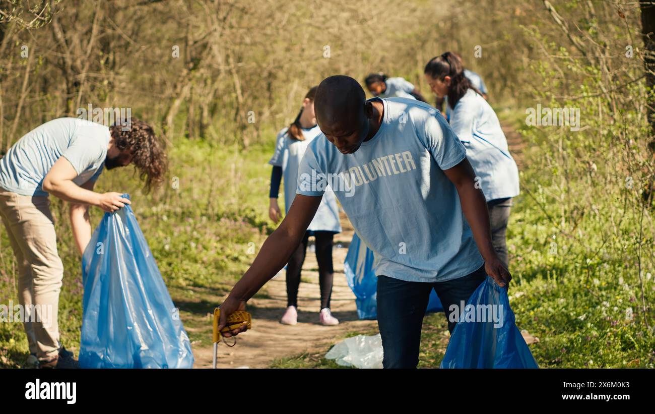 African american man volunteer collecting trash and plastic waste with ...